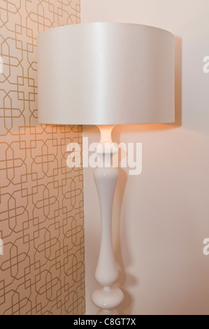 Interior of stylish room with golden standard lamp, table and pouf ...