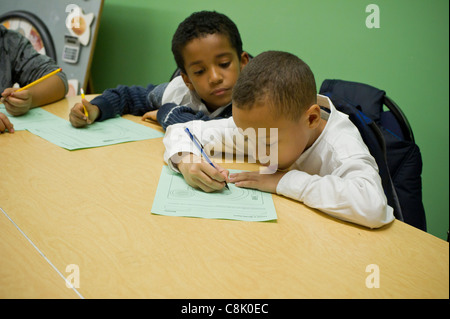 Second and third graders do an assignment during an after school ...