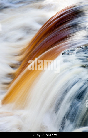 Peat coloured water flowing over a waterfall formed by the inclined ...