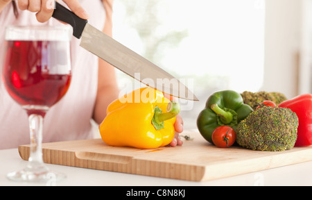 Woman cutting pepper at table in kitchen, closeup Stock Photo - Alamy