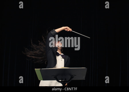 Mixed race conductor pointing baton Stock Photo - Alamy