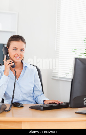 Charming female employee making call Stock Photo - Alamy