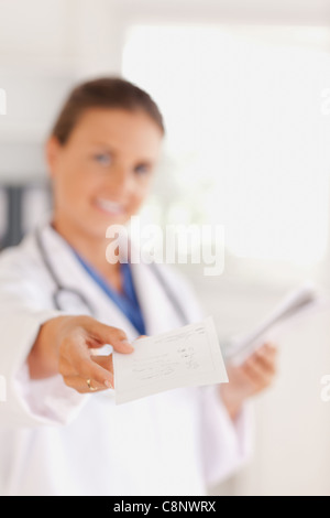 Smiling brunette doctor handing out a prescription Stock Photo - Alamy