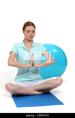 Woman sat in yoga position by exercise ball Stock Photo - Alamy