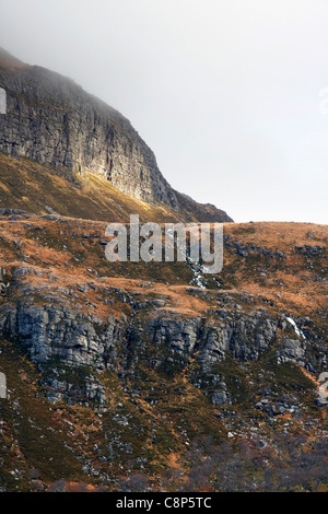 Mountain overgrown in grass with rocky cliffs and slopes covered with ...