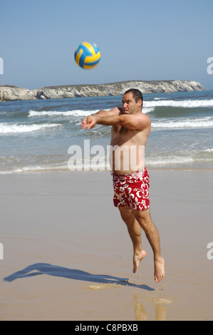 Fat man playing with a ball on the beach Stock Photo - Alamy