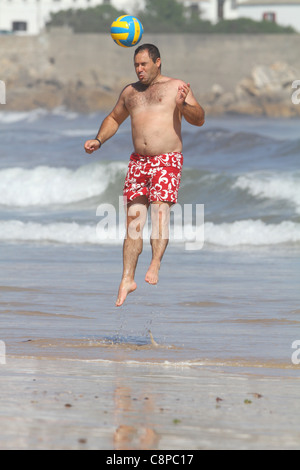 A fat man playing with a ball on the beach Stock Photo - Alamy