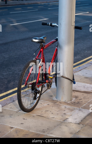 A bicycle secured to a post by a D lock Stock Photo - Alamy