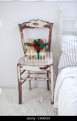 A vertical shot of red chair with a pillow in the corner of the house ...