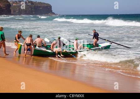 Crew of a traditional australian lifeboat surf rescue boat rowing in a ...