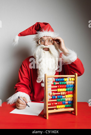 Santa claus in costume and eyeglasses looking at camera near christmas ...