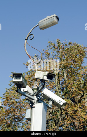 Surveillance cameras mounted on a lamp post against a blue sky ...