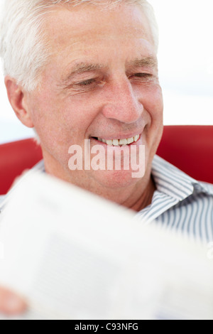 Happy mature man reading a paper document isolated on white background ...