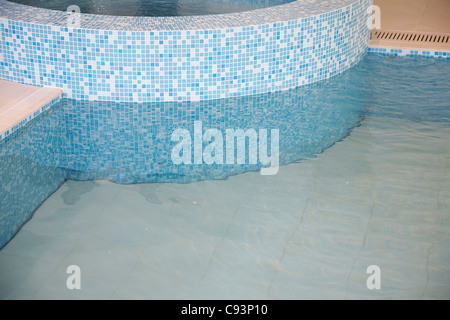 A jacuzzi with blue mosaic tiles at the side of a swimming pool Stock ...