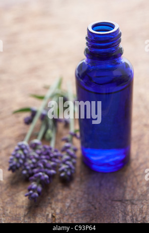 Lavender essential oil glass bottle on wooden table, close up view ...