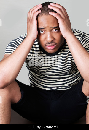 Unhappy man in striped t-shirt screaming and rubbing temples because of ...