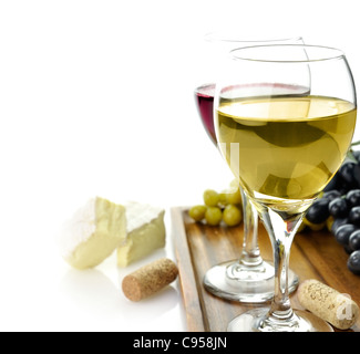 Glasses with red and white wine and cheese on a plate on a light ...