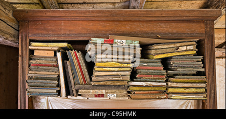 Front view of old books stacked on a shelf. Books without title and ...