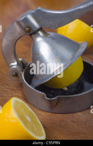 Old lemon squeezer with a lot of lemons Stock Photo - Alamy