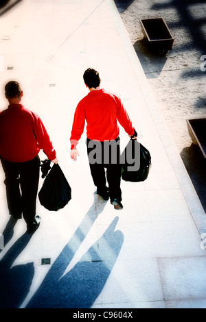 Two men taking out the garbage Stock Photo - Alamy