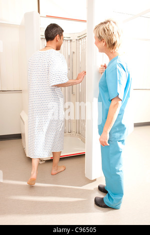 Phototherapy. Dermatologist helping a patient into a phototherapy booth ...