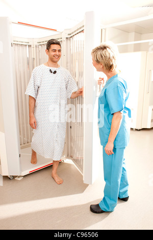 Phototherapy. Dermatologist helping a patient into a phototherapy booth ...