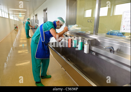 Scrubbing up. Surgeon cleaning her hands before surgery Stock Photo ...