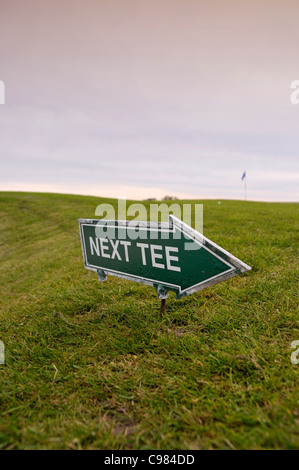 Photo of a Next Tee sign at a golf course with two blurry golfers ...