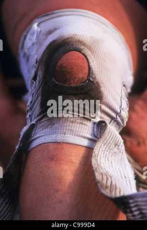 Rugby, knee injury and bandage with a sports black man on a field ...