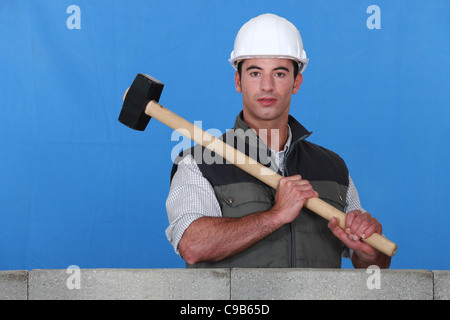 Man lifting hammer next to wall Stock Photo - Alamy