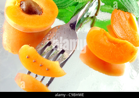 Fresh chilled apricots with mint on a reflective background with a ...