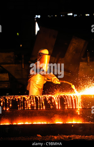 Using gas torch to cut steel reinforcing bars in concrete structure ...