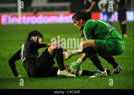 Football teammates helping an injured player off the field to a waiting ...