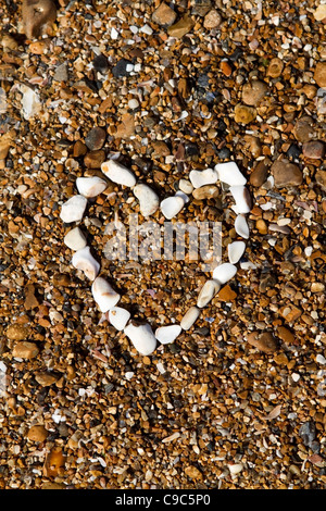 A heart made of white stones and pebbles on a colourful beach Stock ...