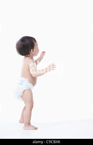 Baby boy in nappy standing Stock Photo - Alamy