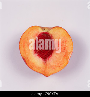 Ripe peach fruit with half in a wicker basket isolated on white ...