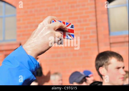 Glasgow Rangers fan with Union Jack flag standing behind an Ulster red ...