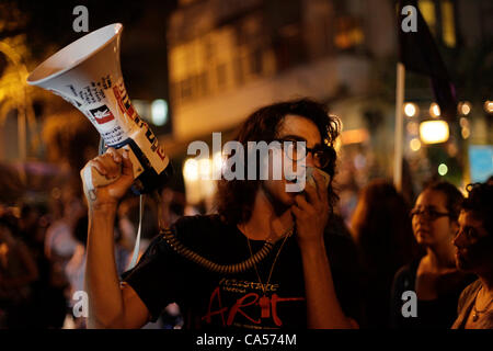 Left-wing Israeli activists chant slogans, bang drums and hold a banner ...