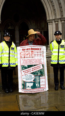 Former News of the World photographer Ian Cutler demonstrates during ...
