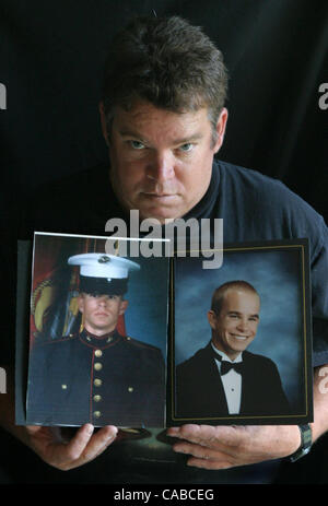 Mark Crowley (cq), father of Kyle Crowley (cq), poses with photos of ...