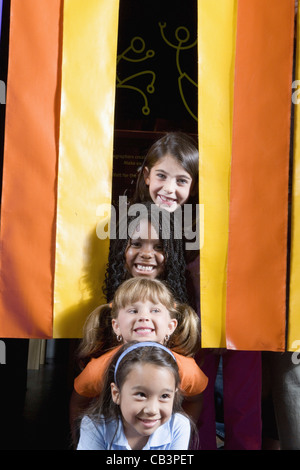 Four girls placing their heads in a vertical row Stock Photo - Alamy