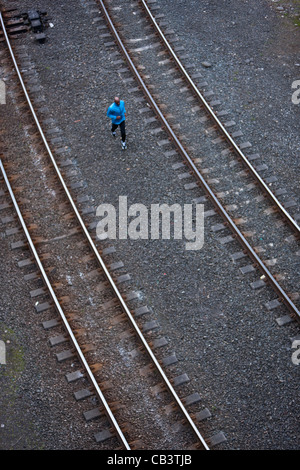 Man running across railroad tracks Stock Photo - Alamy