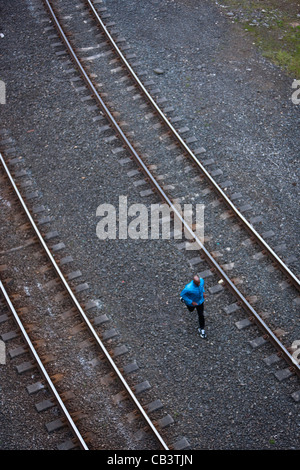 Man running across railroad tracks Stock Photo - Alamy