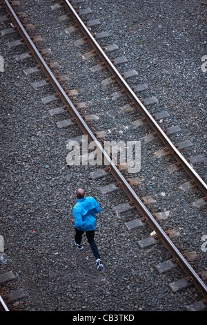 Man running across railroad tracks Stock Photo - Alamy