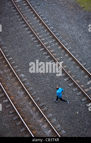 Man running across railroad tracks Stock Photo - Alamy