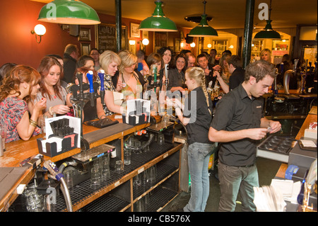 Busy bar filled with young males and females Stock Photo - Alamy