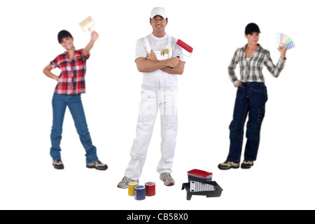 Female house painter with a palette and decorators painting a wall ...