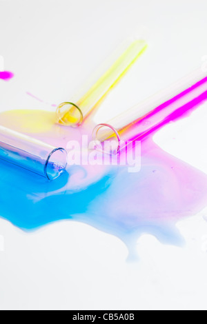 test tubes with colorful substances spilled on a white table in a lab ...