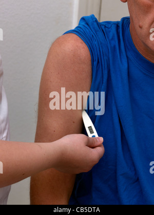 Nurse Placing Digital Thermometer Under A Patient's Arm Taking ...