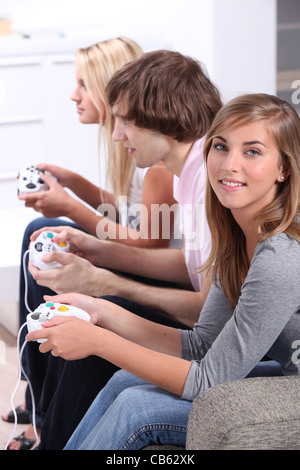 Three teenagers playing video games Stock Photo - Alamy